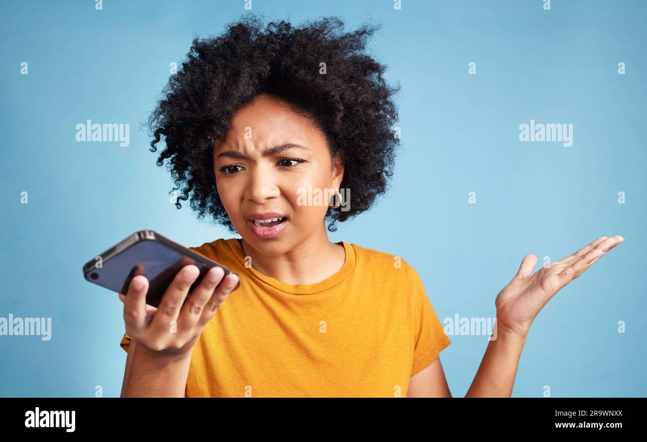 Confused, phone and african woman isolated on blue background for ...