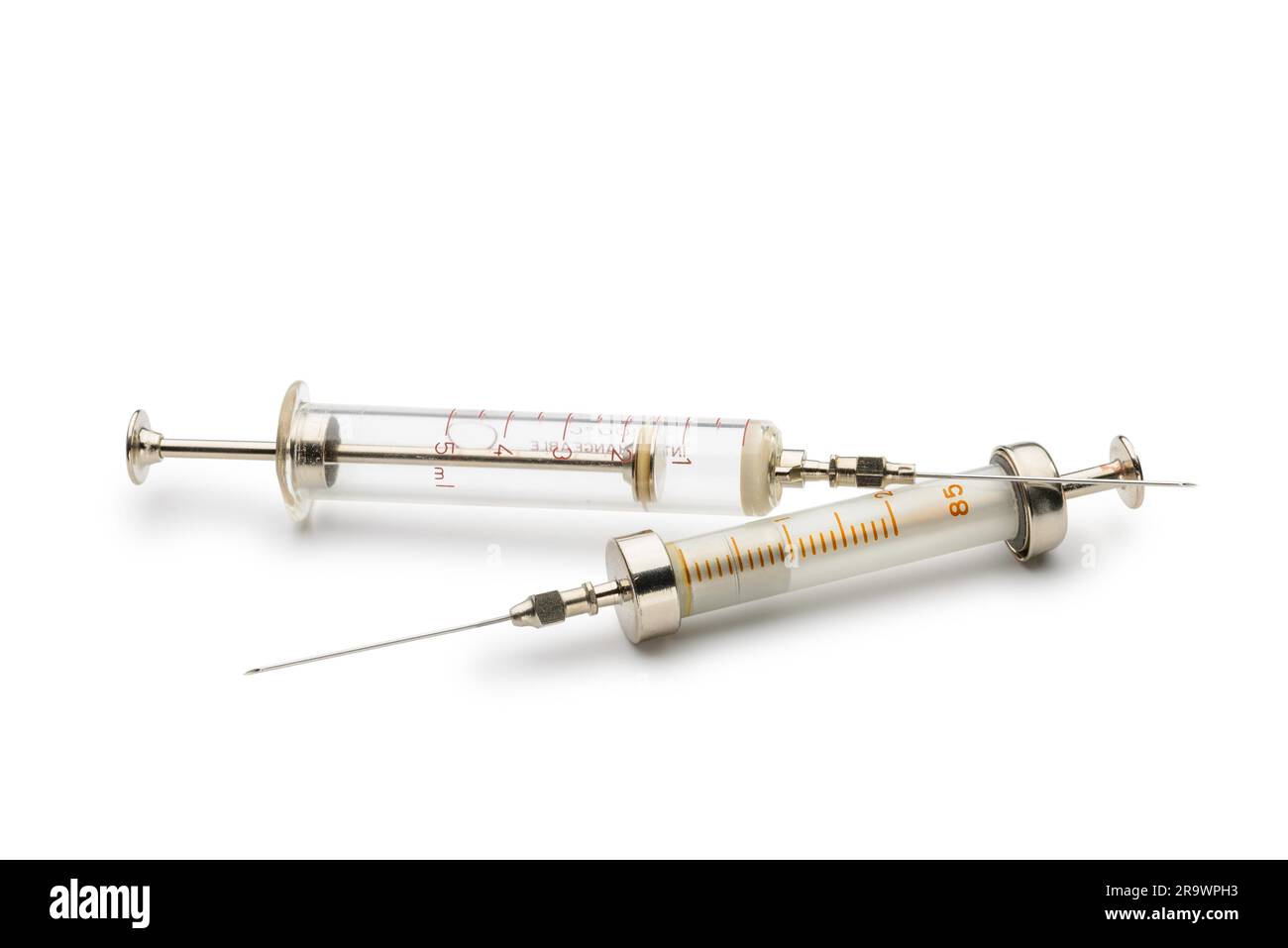 Two glass syringes isolated on white background Stock Photo - Alamy