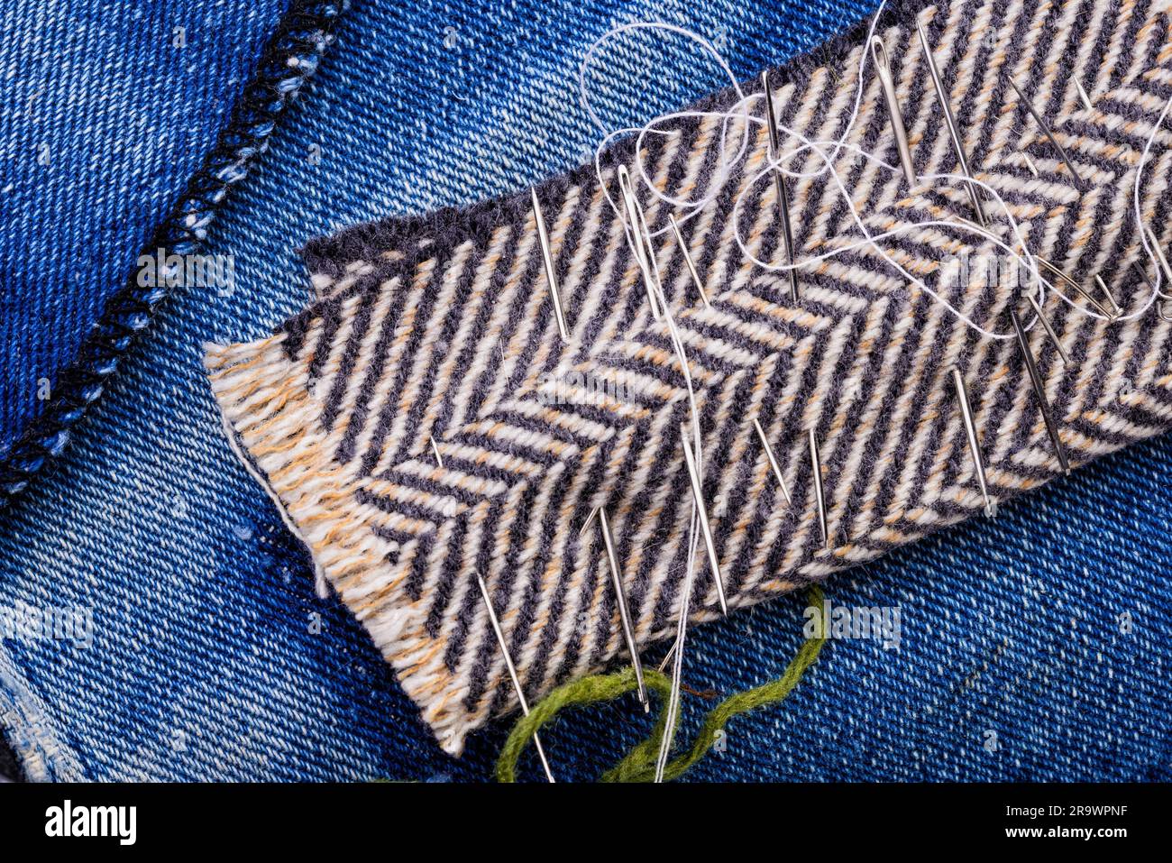 Various needles ready to needlework with blue jeans and fabric Stock ...