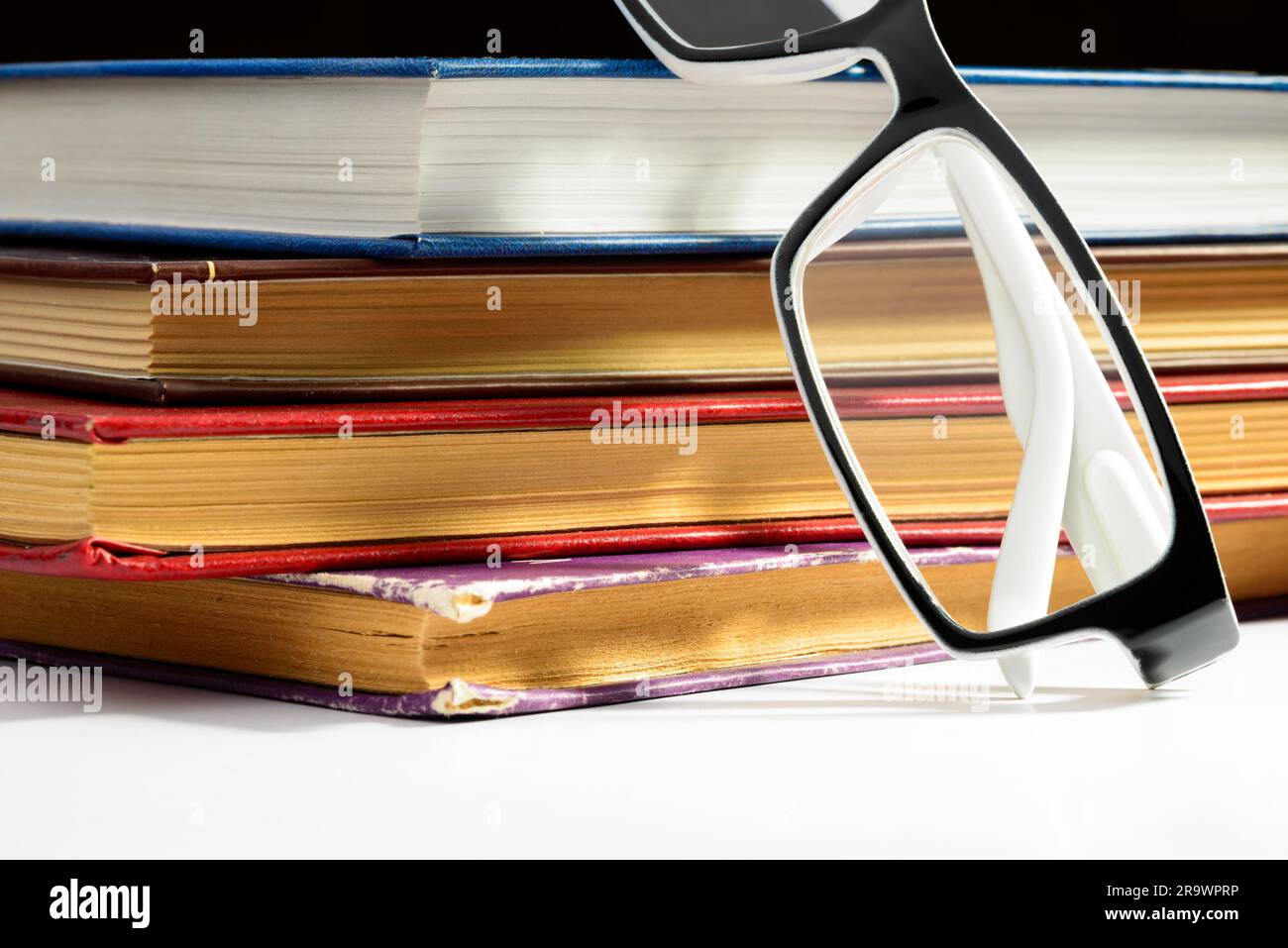 A pile of old books to read using glasses Stock Photo - Alamy