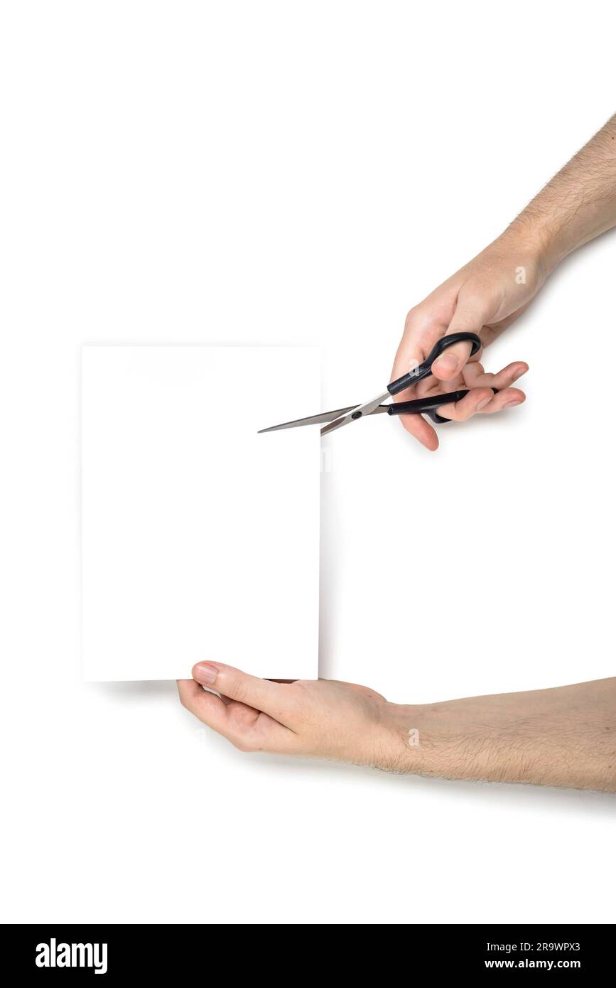 A woman is cutting a sheet of white paper using metallic scissors ...