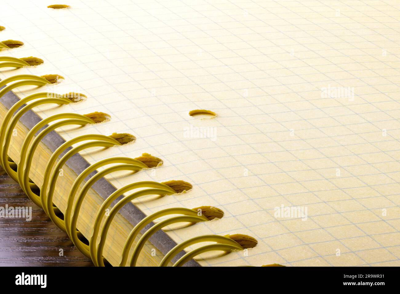 Macro of the spiral of a yellow paper notebook with large deep of field ...