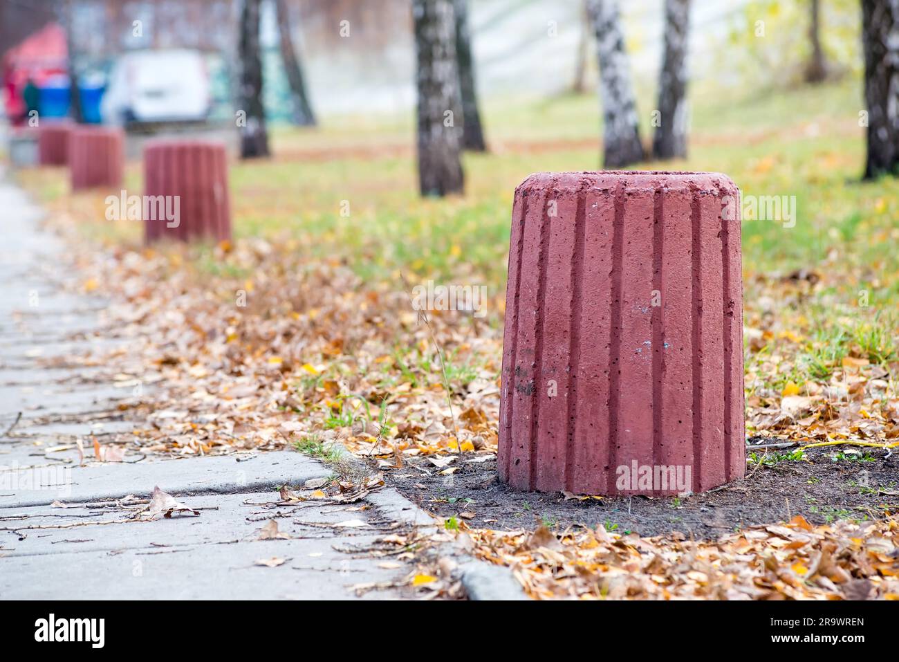 New red cement trash bin in the park in autumn Stock Photo - Alamy