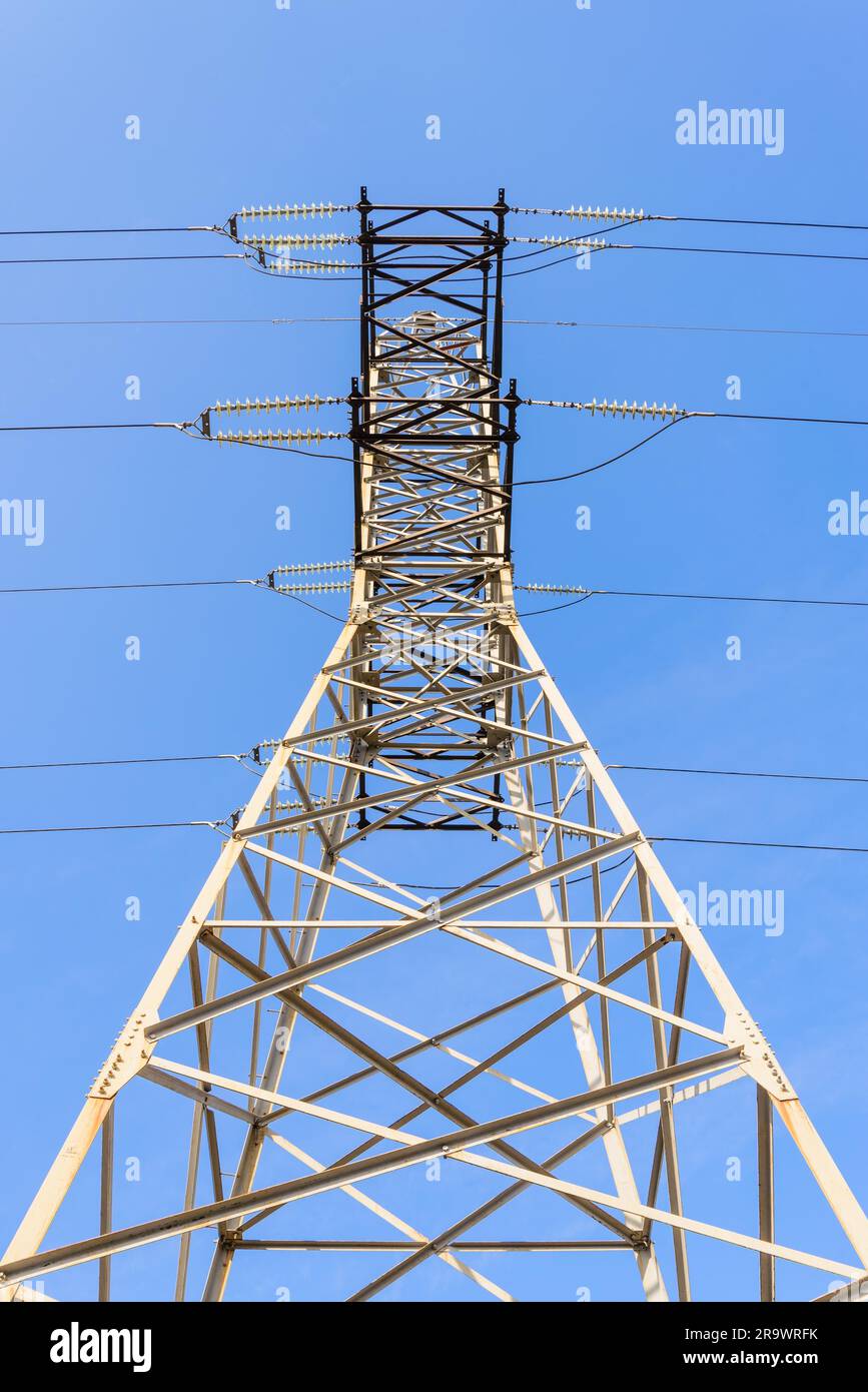Detail of an electricity pylon against blue sky: high voltage electric ...