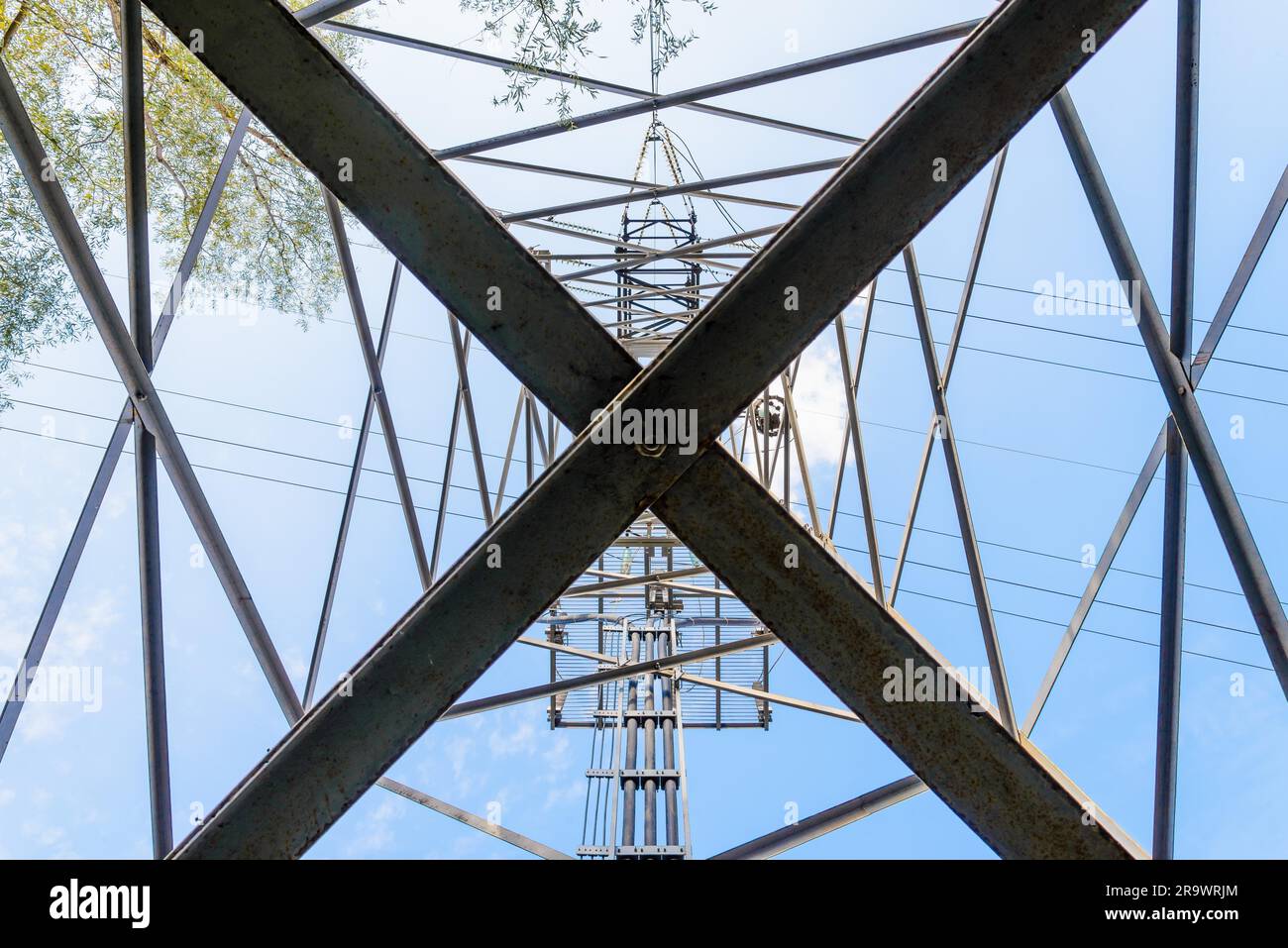 Detail of an electricity pylon against blue sky: high voltage electric ...