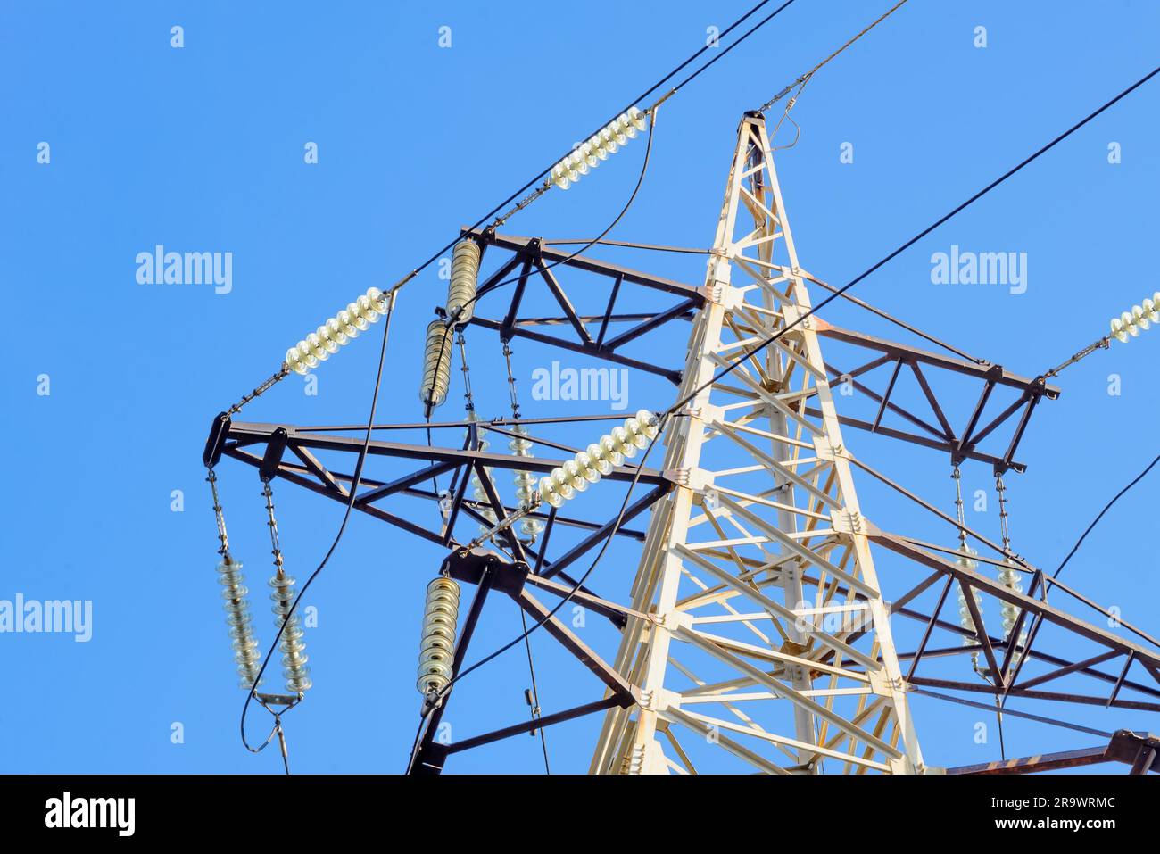 Electricity pylon against blue sky: high voltage electric cables seen ...