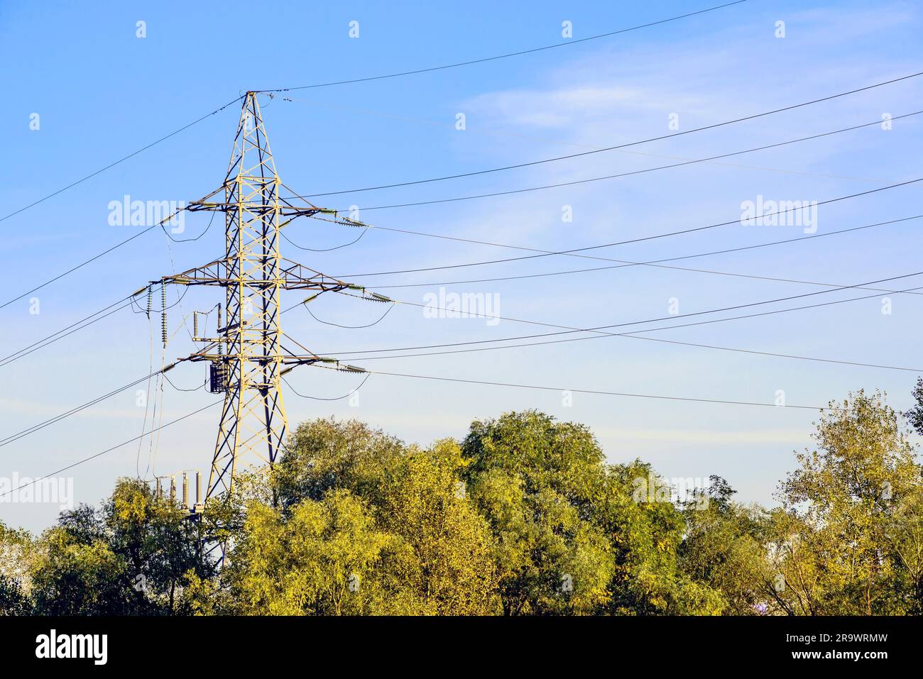 Electricity pylon against blue sky: high voltage electric cables seen ...