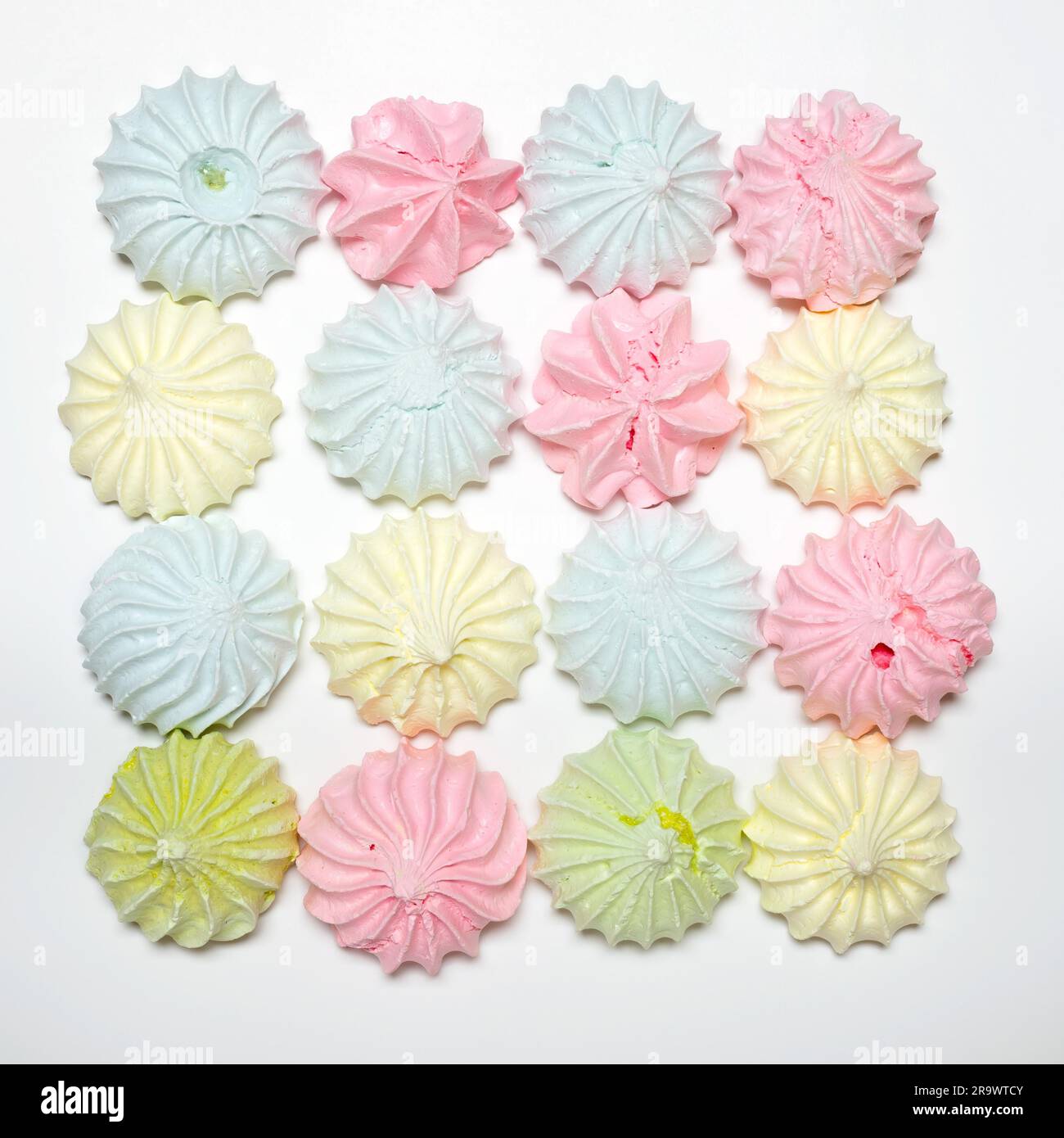 Sixteen colored french meringues aligned in a square, on white ...
