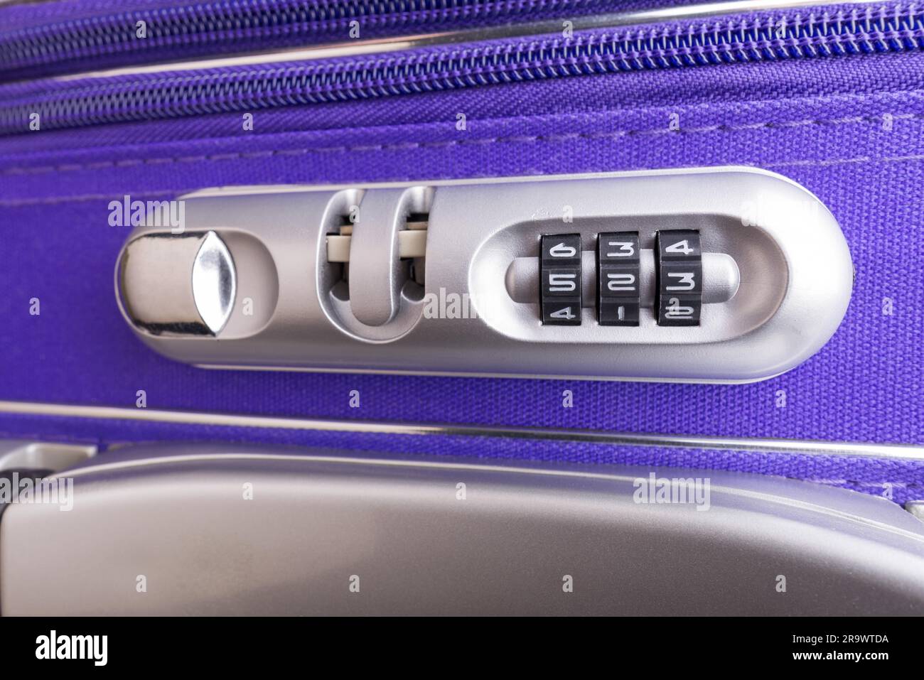 Closeup of a security padlock with three numbers on a violet suitcase ...