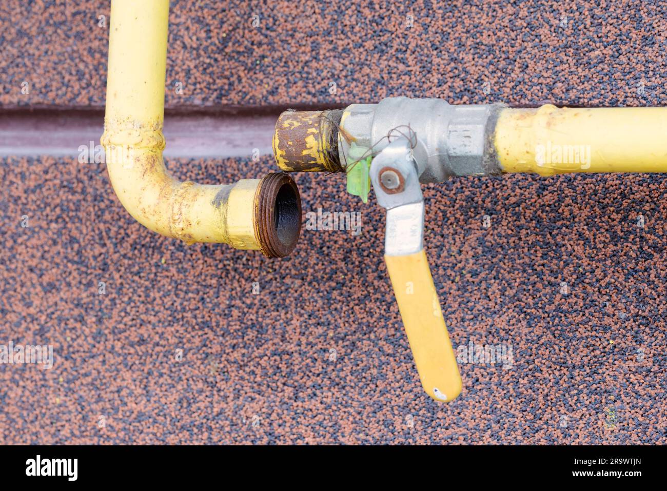 A broken yellow gas tube, with a tap, outside of a house to canalize ...