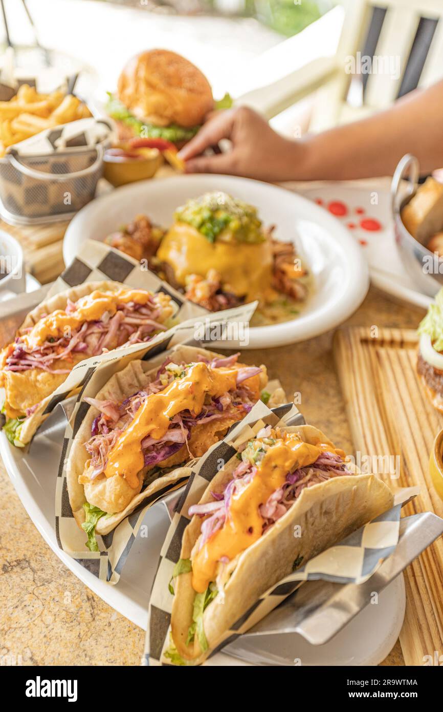 A set of tacos arranged on plates at a dining table, creating a ...