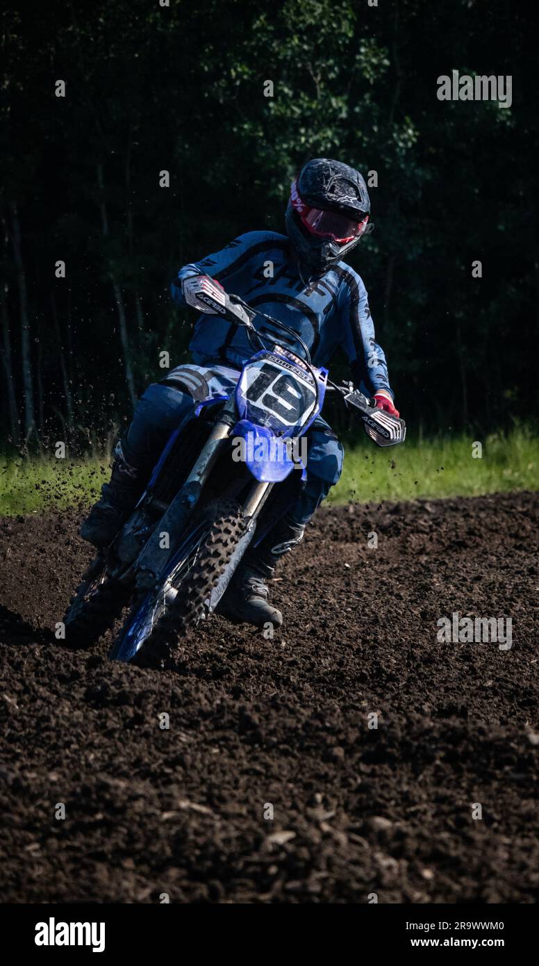 A man in racing suit riding a motorcycle on a dirt track Stock Photo ...