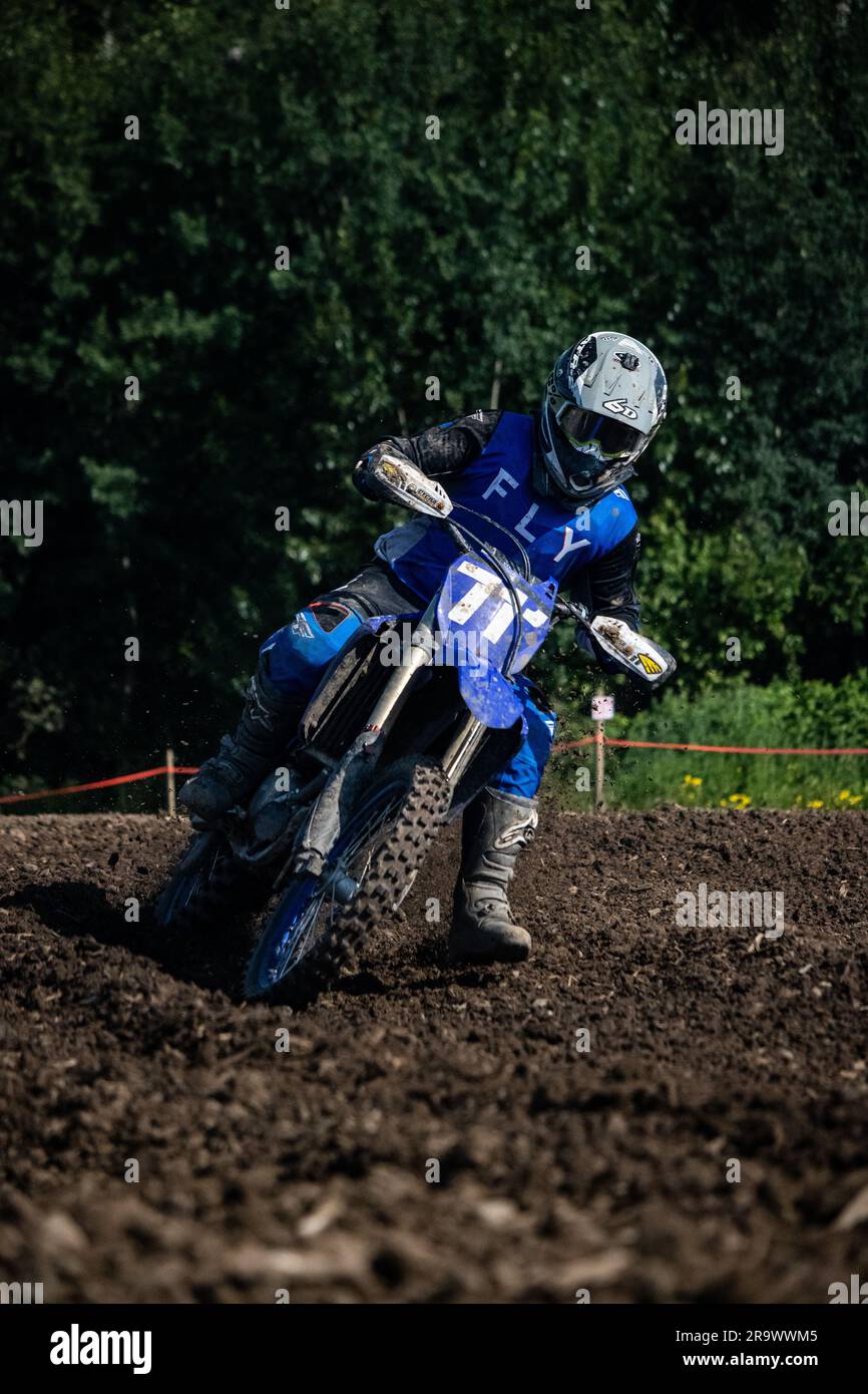 A man in racing suit riding a motorcycle on a dirt track Stock Photo ...