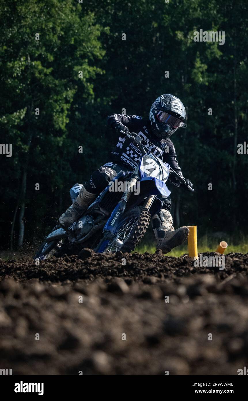 A man in racing suit riding a motorcycle on a dirt track Stock Photo ...