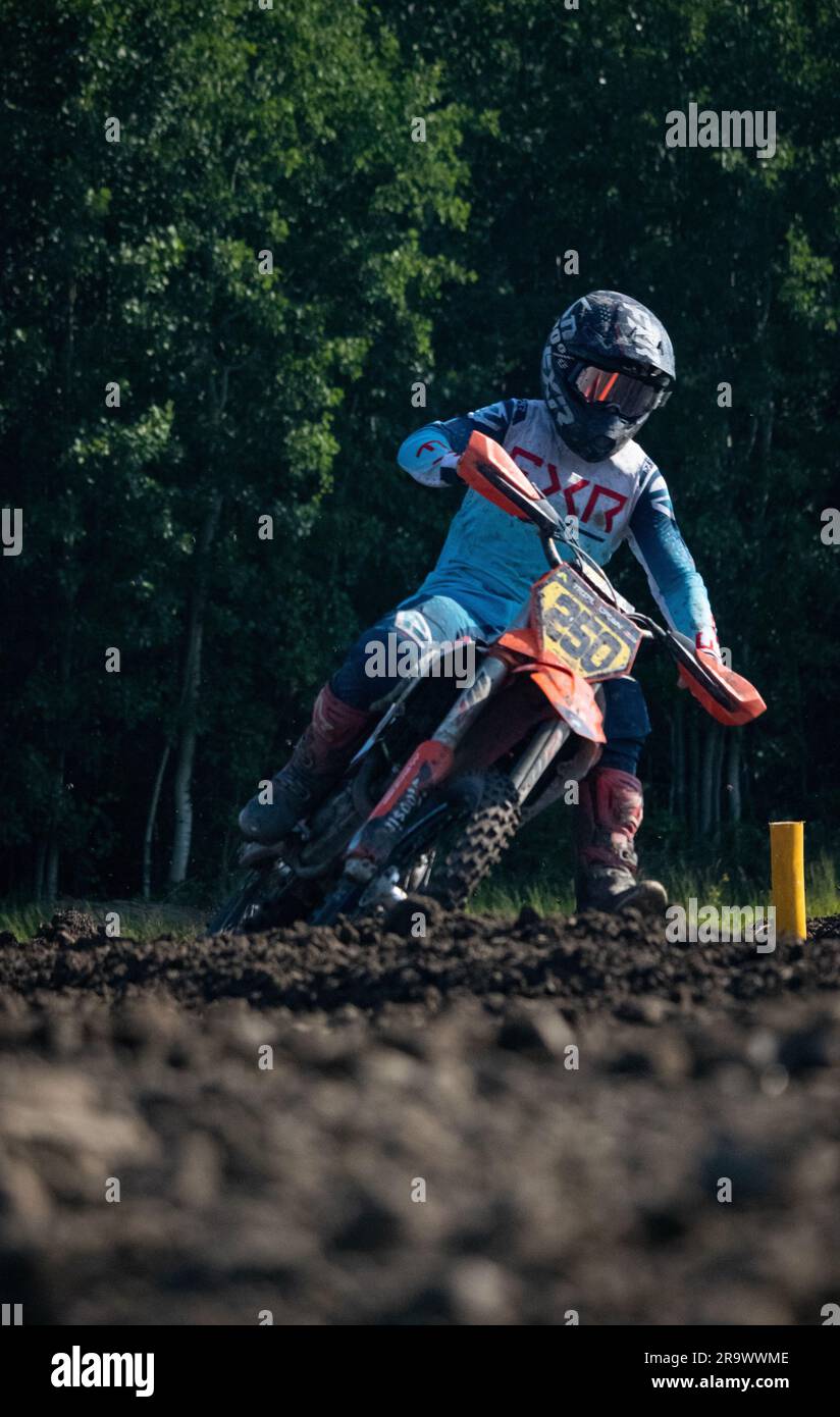 A man in racing suit riding a motorcycle on a dirt track Stock Photo ...