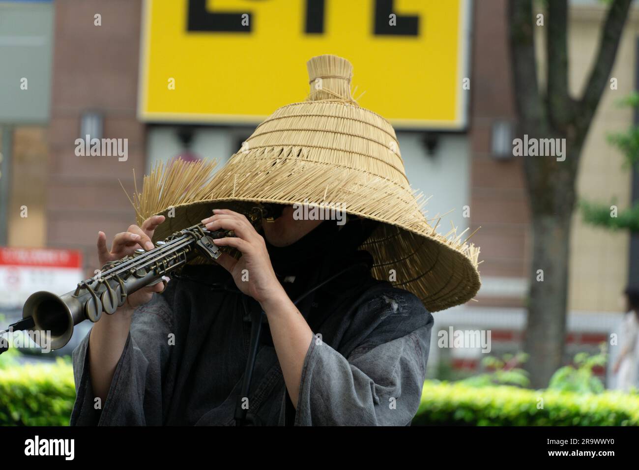 A person wearing a straw hat while playing a soprano saxophone Stock ...