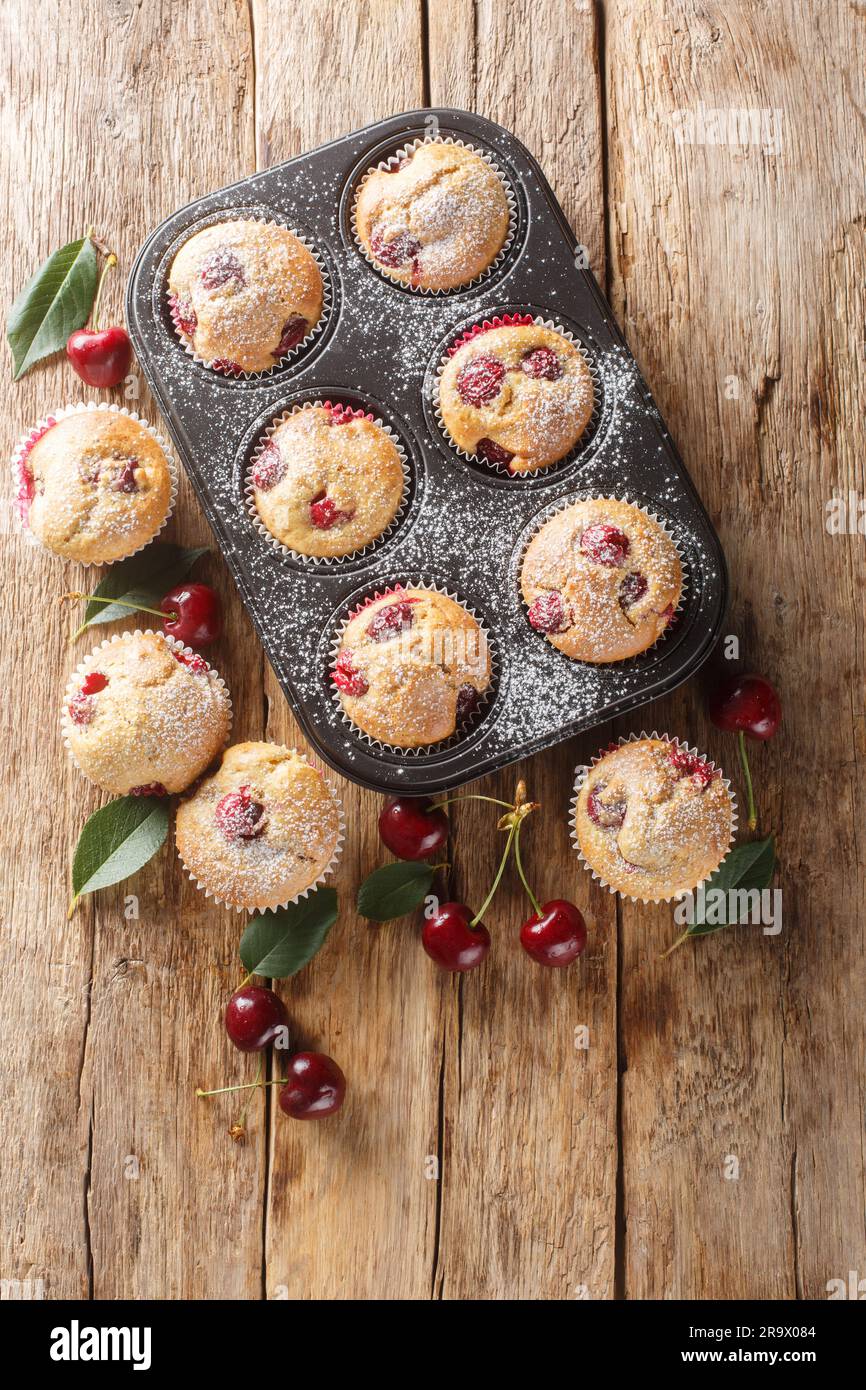 Homemade cherry muffins in cupcake liners and fresh cherries in the ...