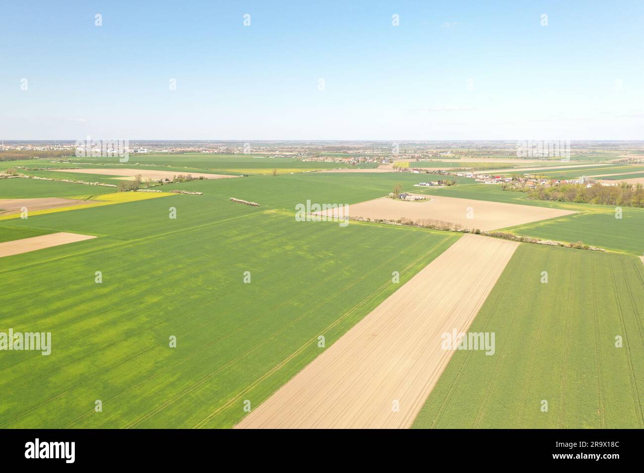 An aerial view of a rural landscape with cultivated fields, crop lines ...