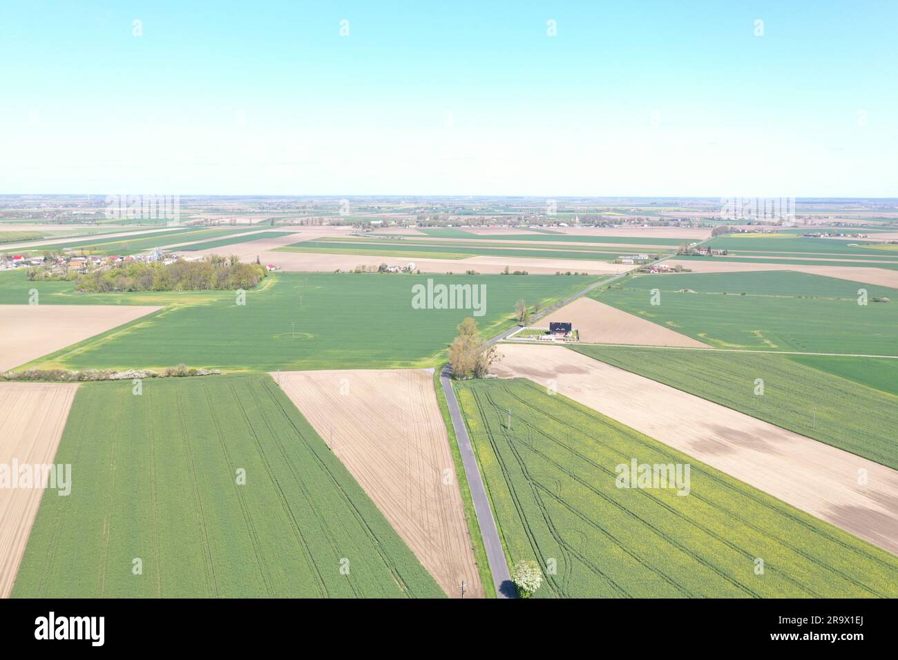 An aerial view of a rural landscape with cultivated fields, crop lines ...