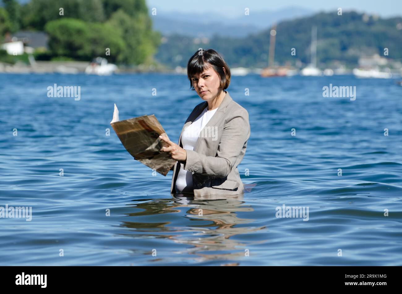 Elegant Business Woman with Suit Standing in the Water and Reading a ...