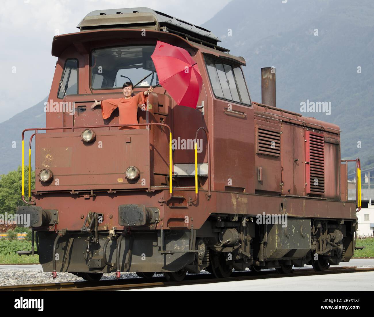 Happy Woman Standing on Train with a Red Umbrella Stock Photo - Alamy