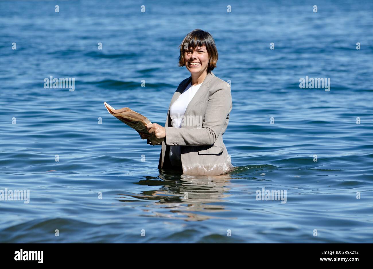 Elegant Business Woman with Suit Standing in the Water and Reading a ...