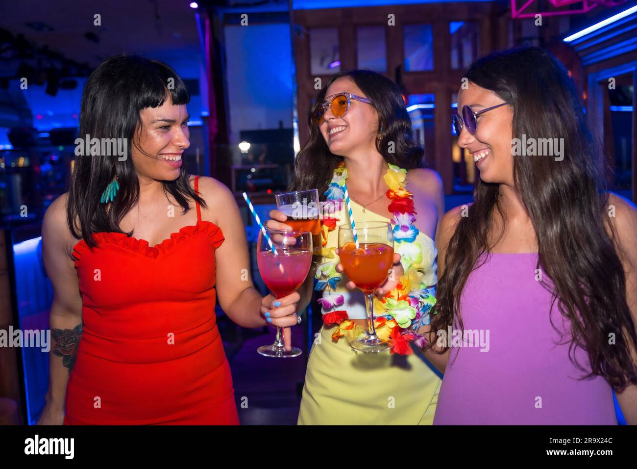 Female friends in a nightclub having fun dancing at a summer night ...
