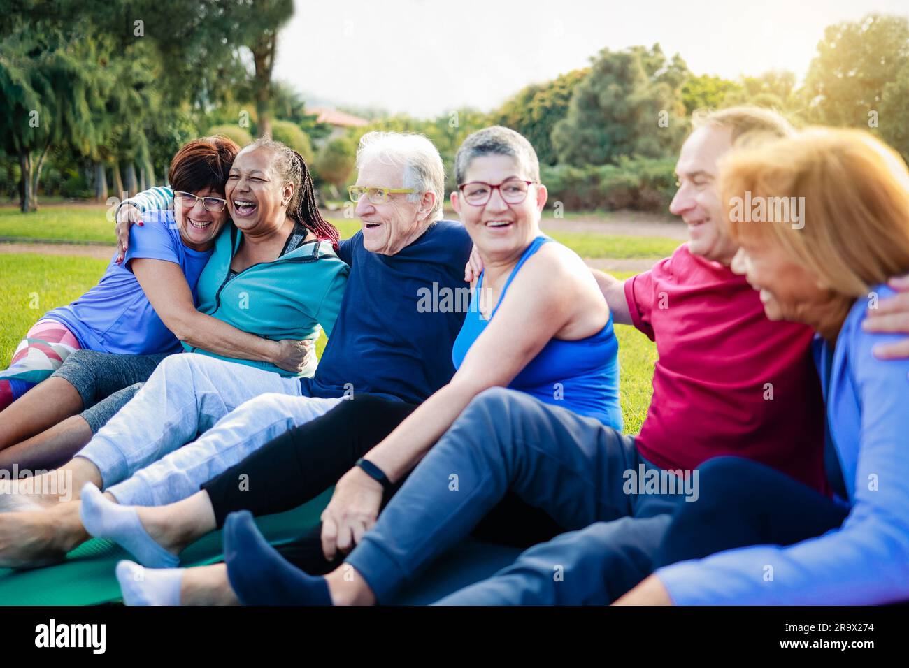 Happy senior people after yoga sport class having fun sitting outdoors ...