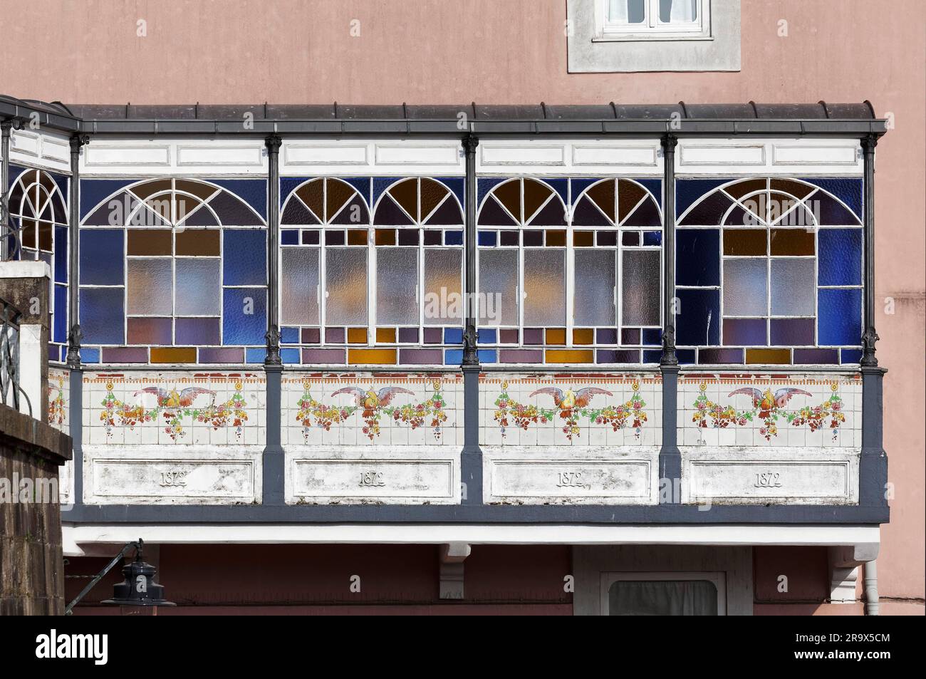 Bay window with stained glass windows and painted tiles, historic house ...
