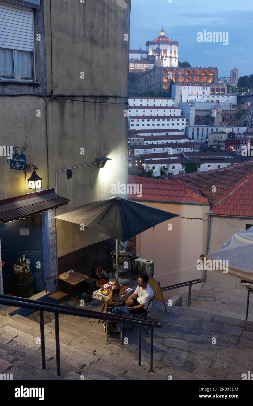 Two restaurant guests sitting at a table in a steep staircase with a ...