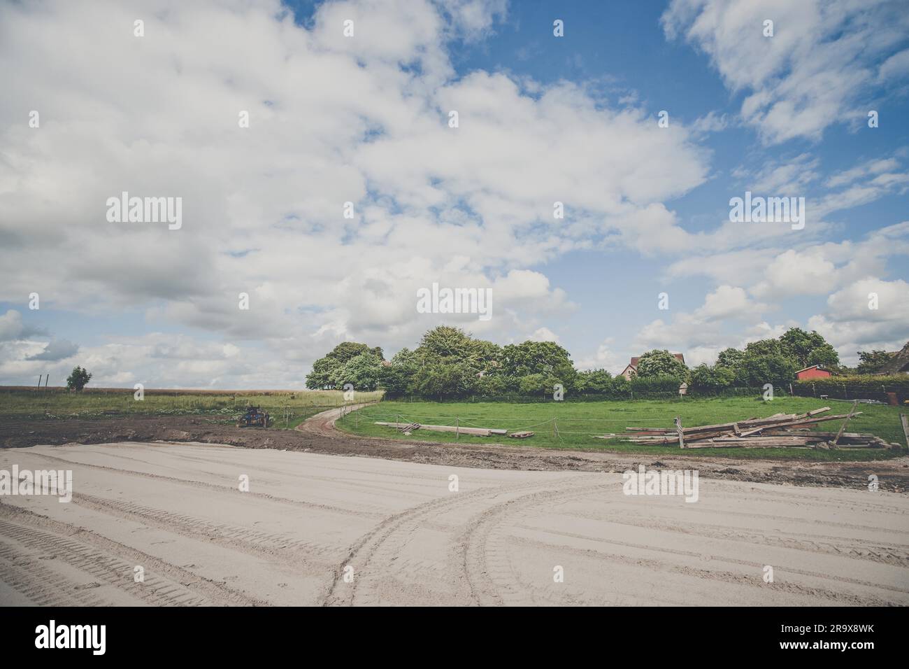 Large rural yard with tracks in sand and green fields Stock Photo - Alamy