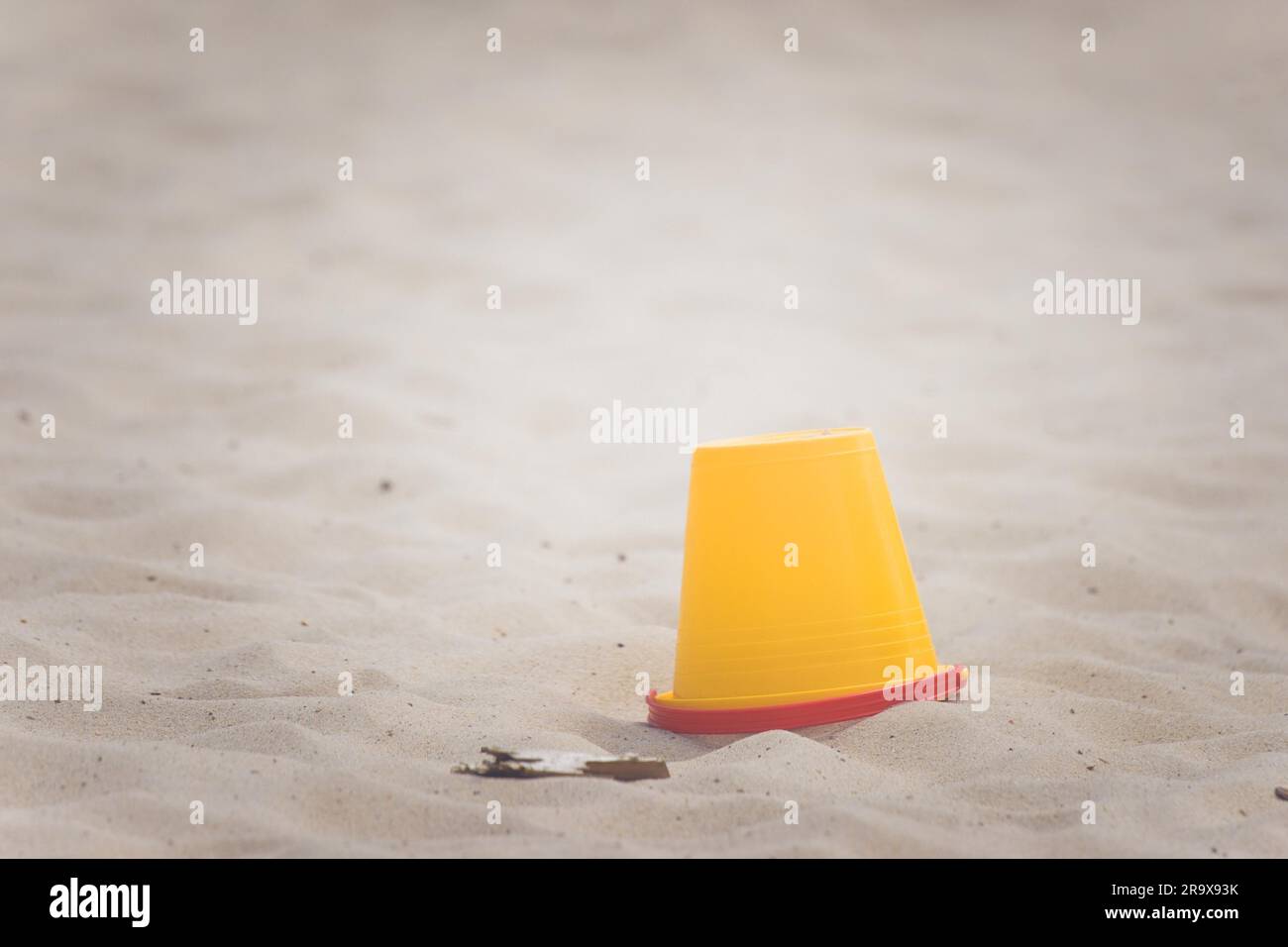 Yellow bucket on a sandy beach in the summer Stock Photo - Alamy
