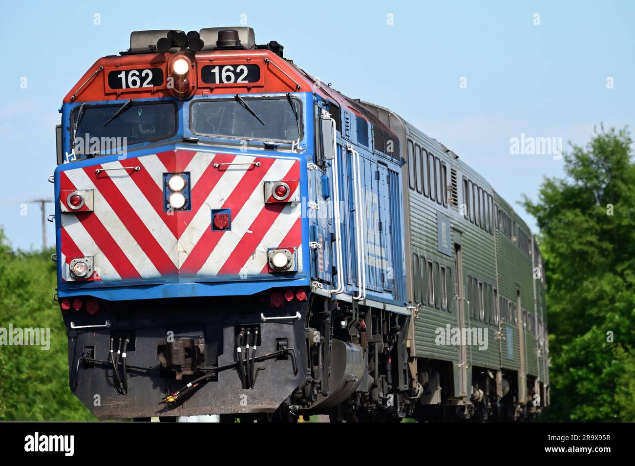 West Chicago, Illinois, USA. A Metra locomotive powers its commuter ...