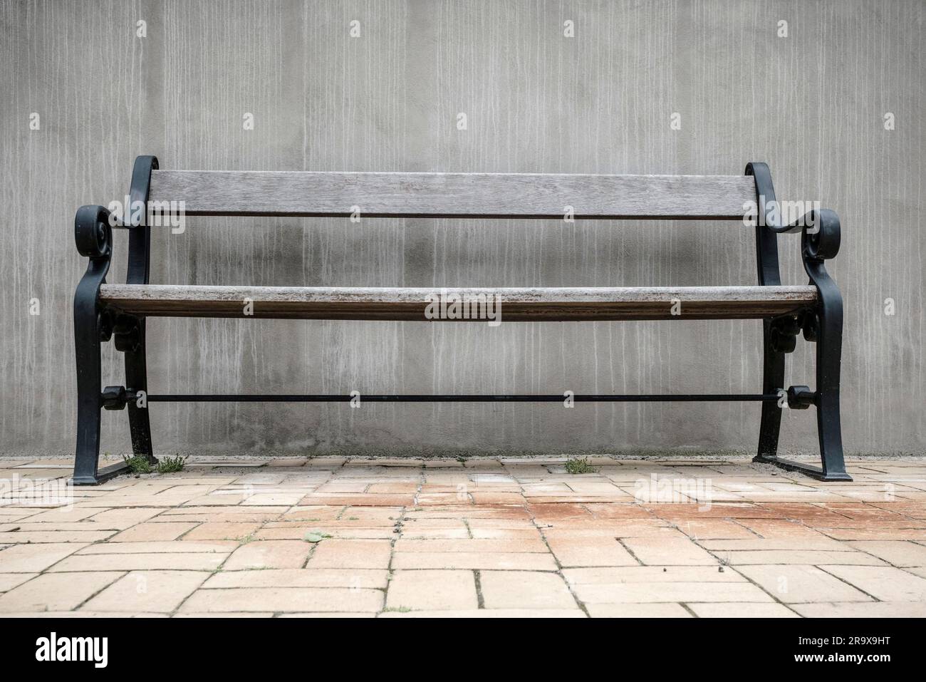 Wooden bench in vintage style on a terrace with a large concrete wall ...
