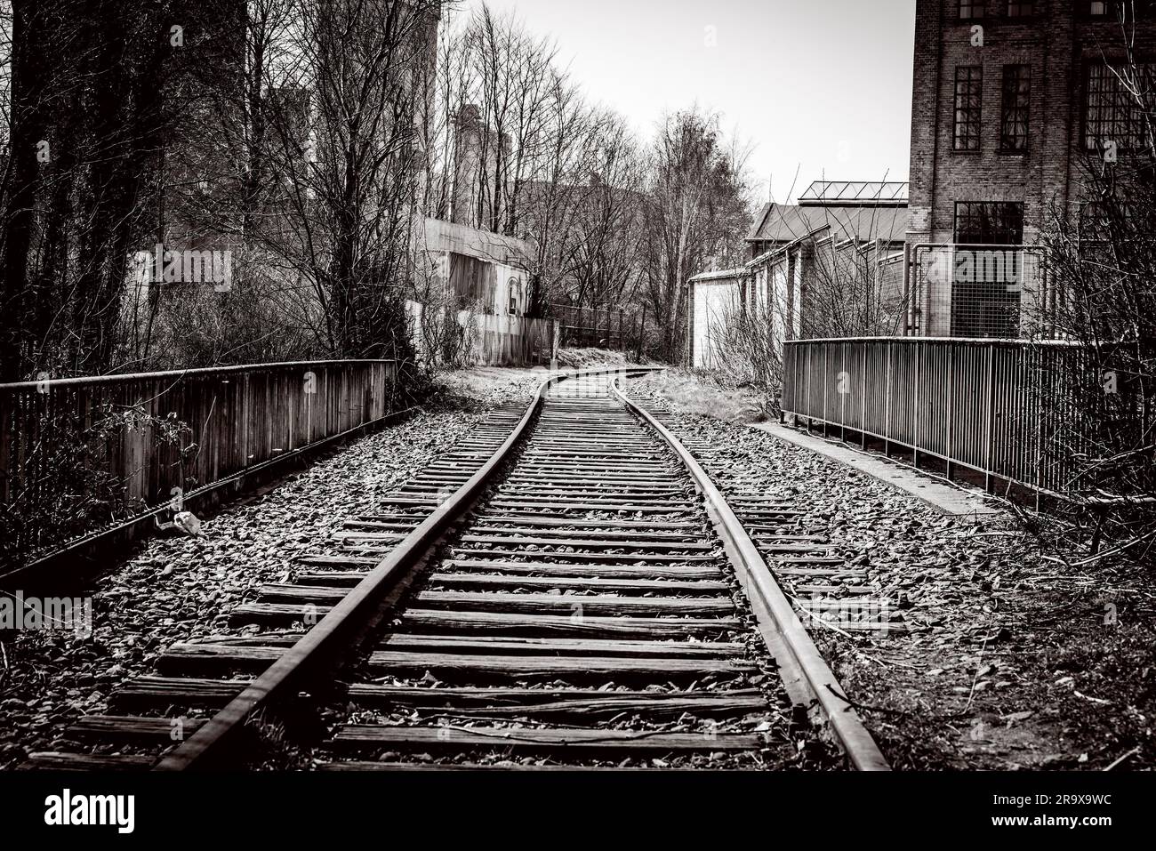 Railroad tracks going through an abandoned city with old buildings ...
