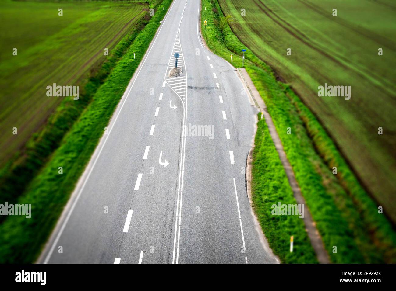 Highway road with white stripes with rural fields on both sides seen ...