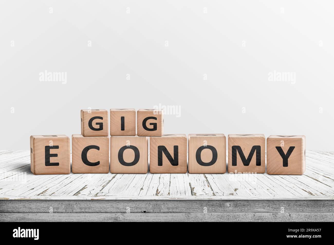 Gig economy sign made of wood on a worn table with white painted planks ...