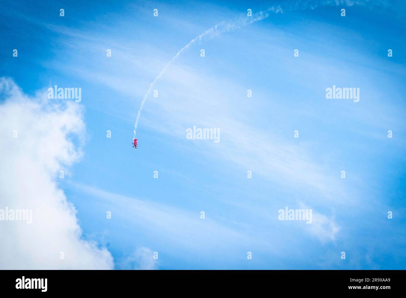 Veteran airplane makes a loop in the sky with smoke at its tail Stock ...