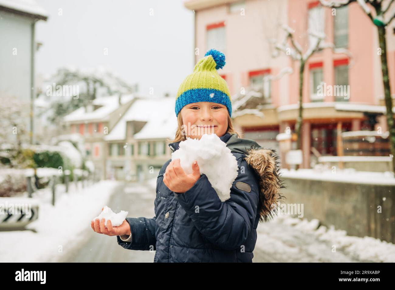 Winter portrait of cute little boy wearing warm jacket, hat, holding ...