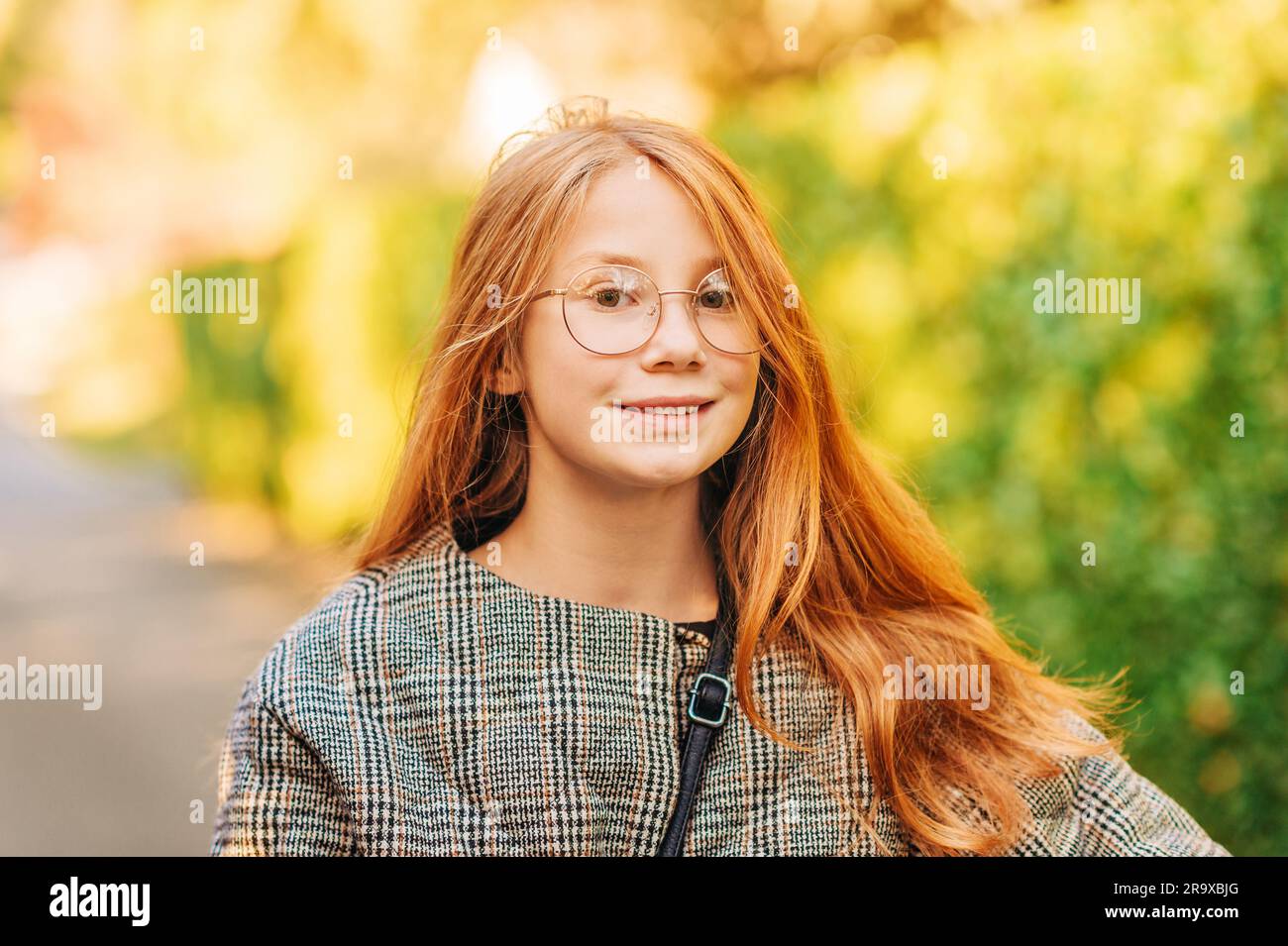 Outdoor close up portrait of beautiful red-haired preteen girl wearing ...