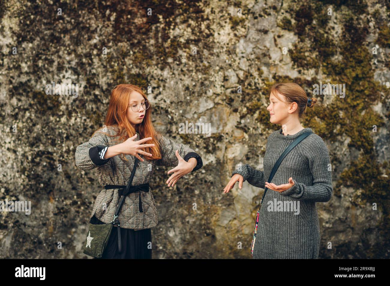Two young expressive girls having active conversation Stock Photo - Alamy