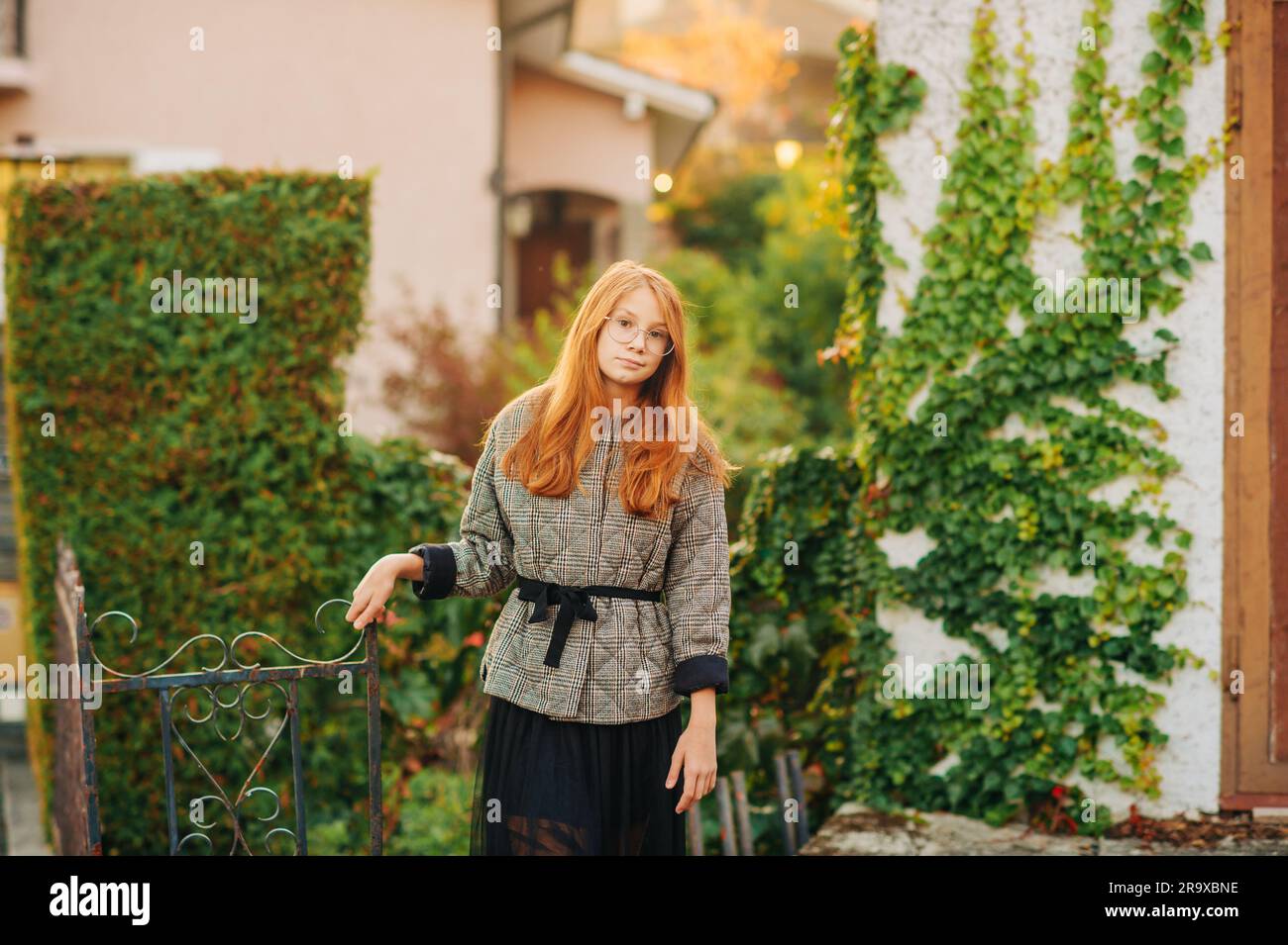 Portrait of adorable little red-haired girl, posing outside, wearing ...