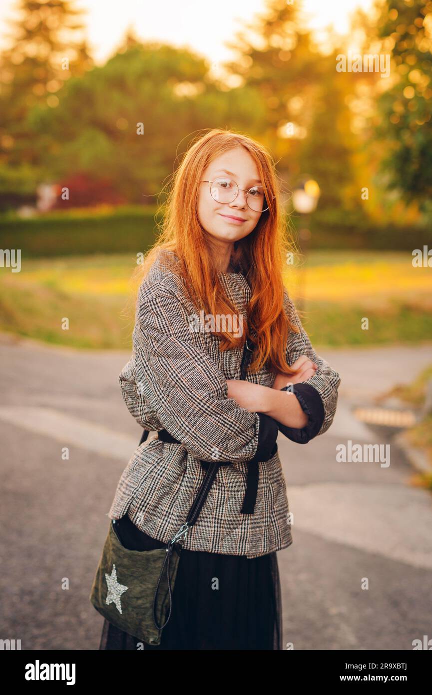 Outdoor close up portrait of beautiful red-haired preteen girl wearing ...