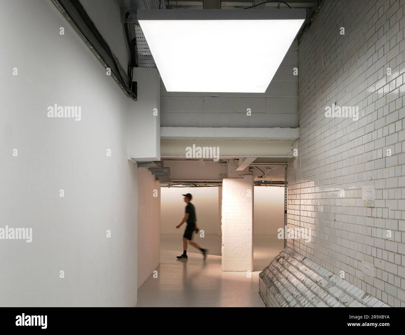 Corridor with passing figure. Victoria House Basement, London, United ...