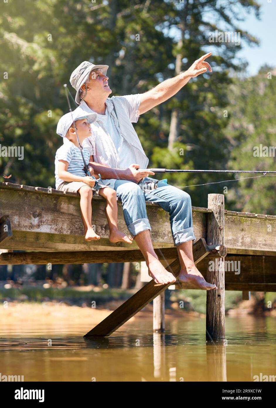 Grandfather, child and pointing while fishing at lake for fun hobby ...