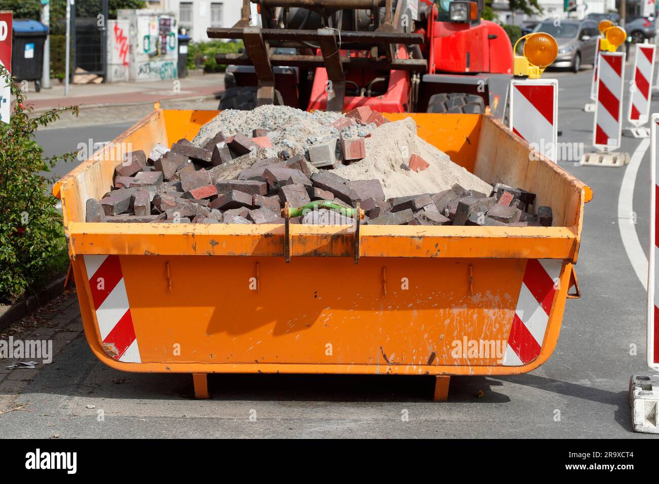 Container, orange skip for construction waste standing on the road ...