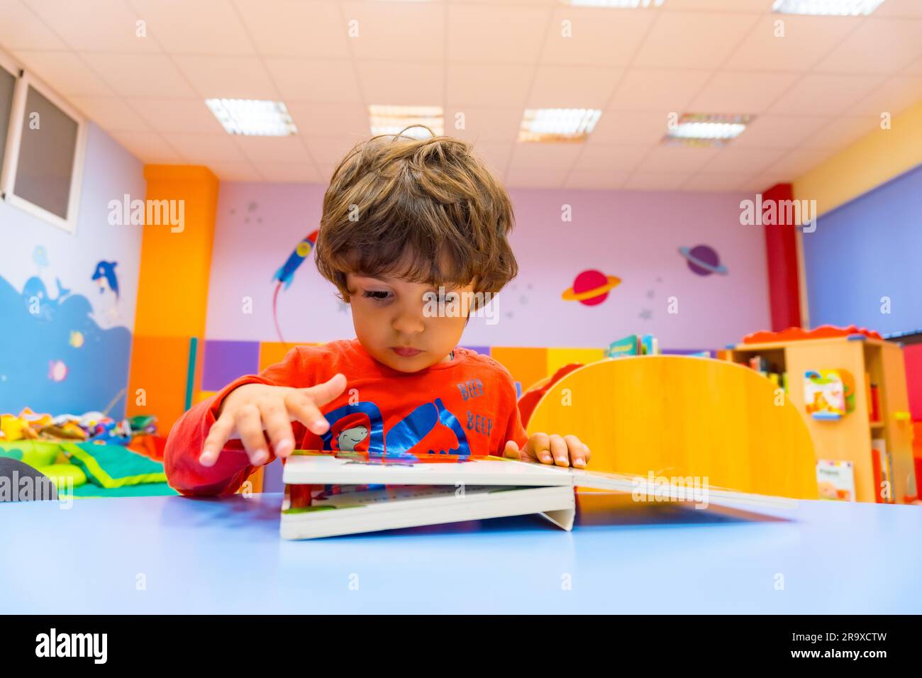 Portrait of a child sitting reading a story book, indoor of a ...