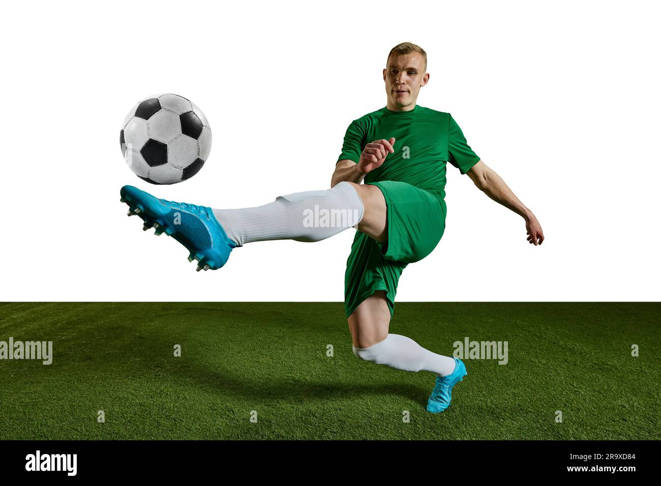 Competitive man, football player in green uniform training, kicking ...