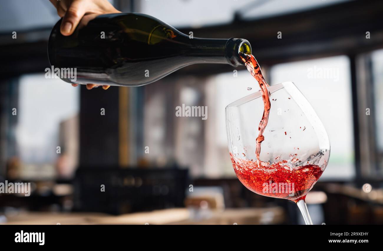 Waiter pouring red wine Stock Photo - Alamy