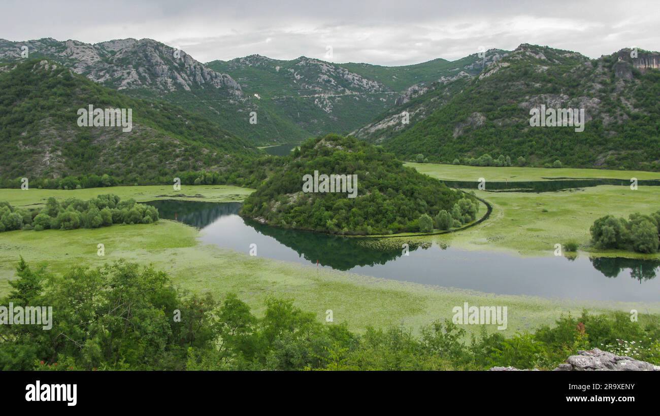 panoramic view of the island on Skadar Lake and the forested mountains ...